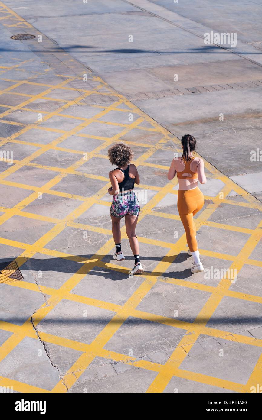 Two women running along road hi-res stock photography and images - Alamy
