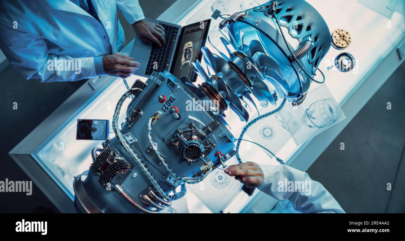 Two Professional Jet Engine Researchers Discussing Work, Using Laptop ...