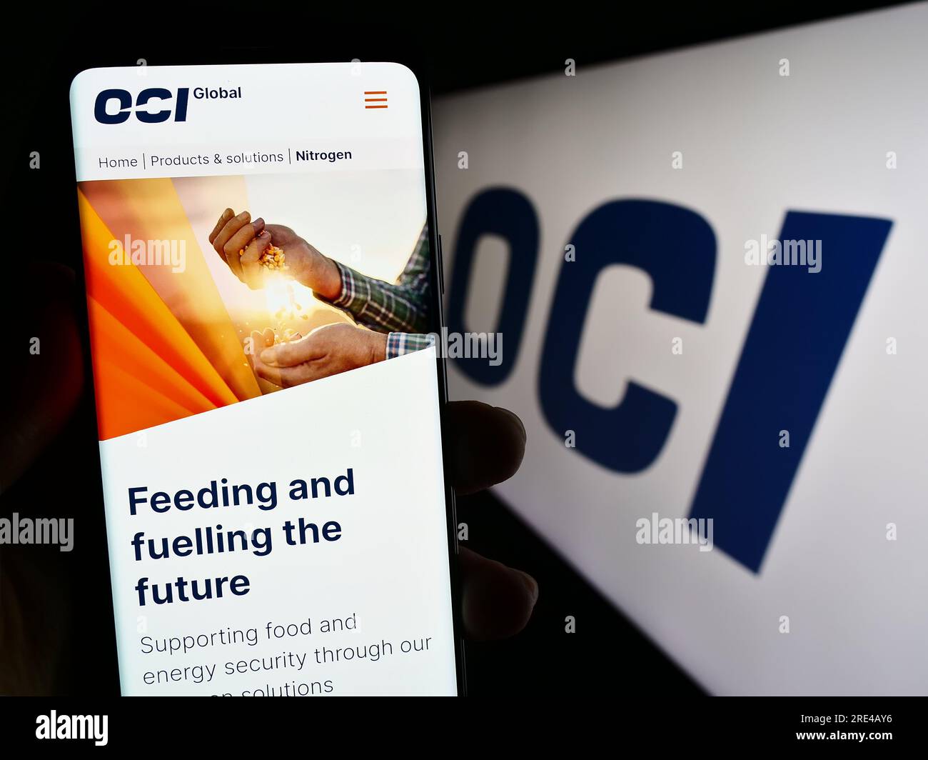 Person holding smartphone with web page of Dutch chemical company OCI N ...