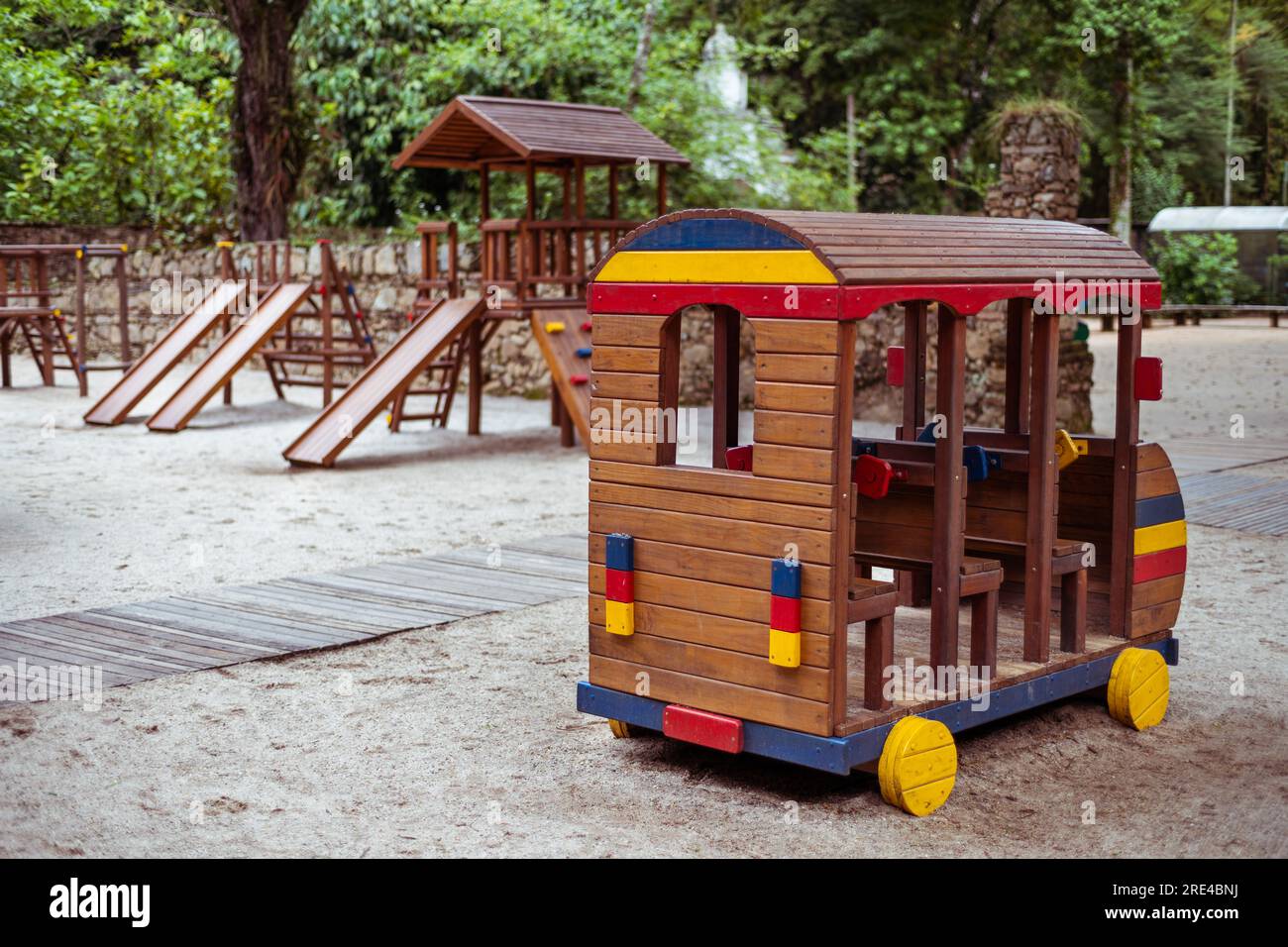 Selective focus on a colorful wooden kid's car or a bus on the sandy ...