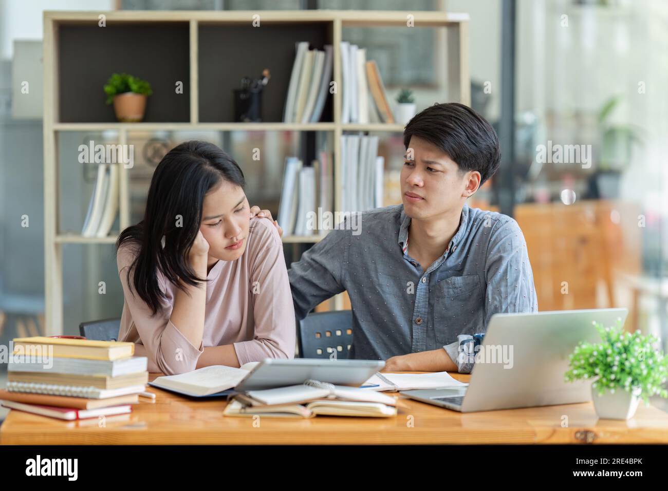 Two Asian students learning together and tutor together at cafe and ...