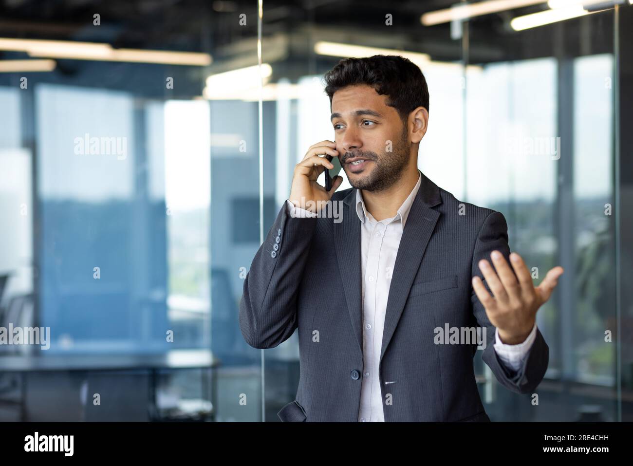 Serious Arab boss talking on the phone, businessman in a business suit ...