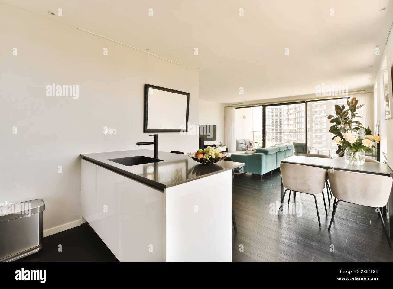 a kitchen and dining area in a modern apartment with white walls, dark ...