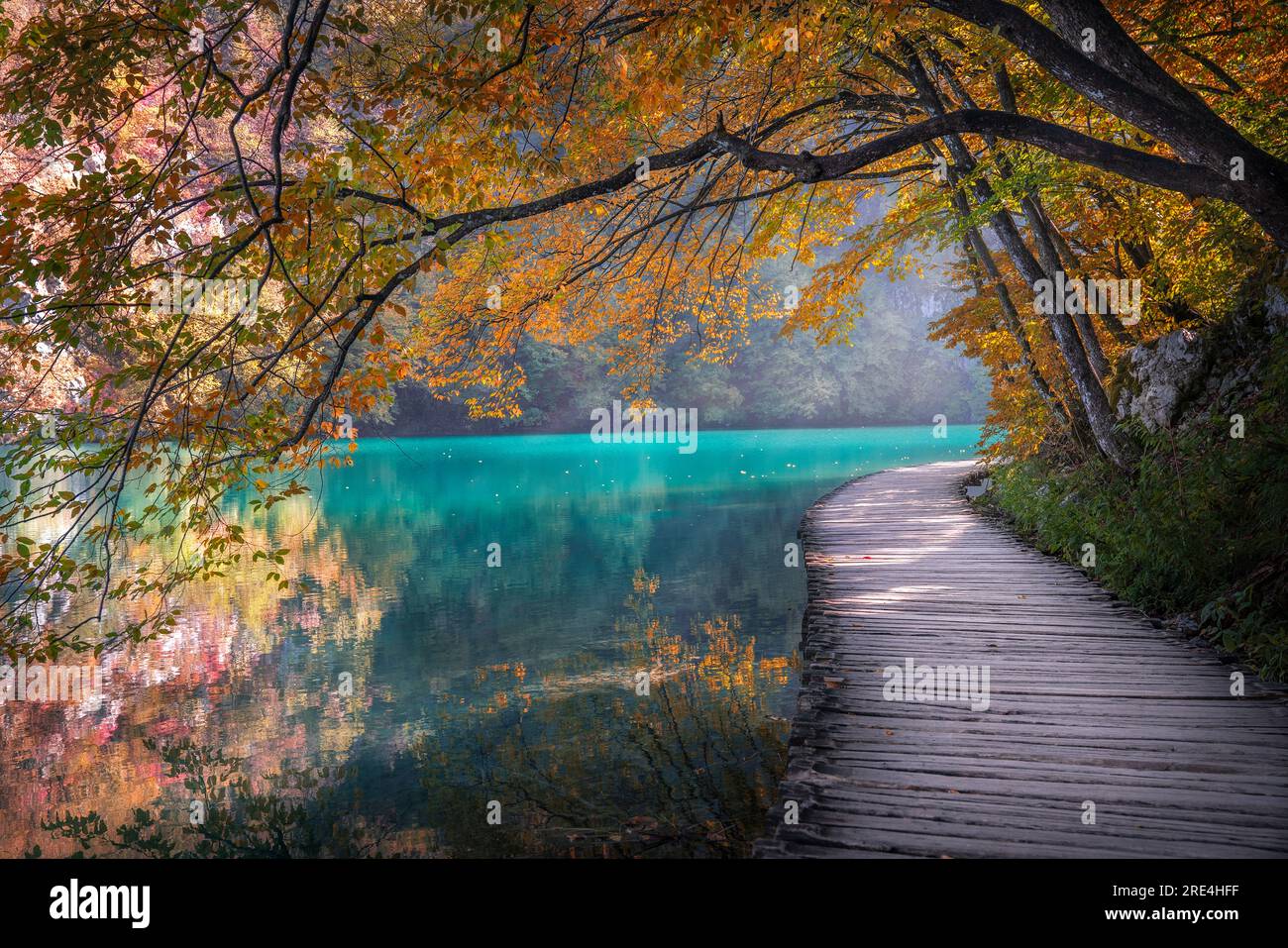 Wooden path along a lake with clear, blue water Stock Photo - Alamy