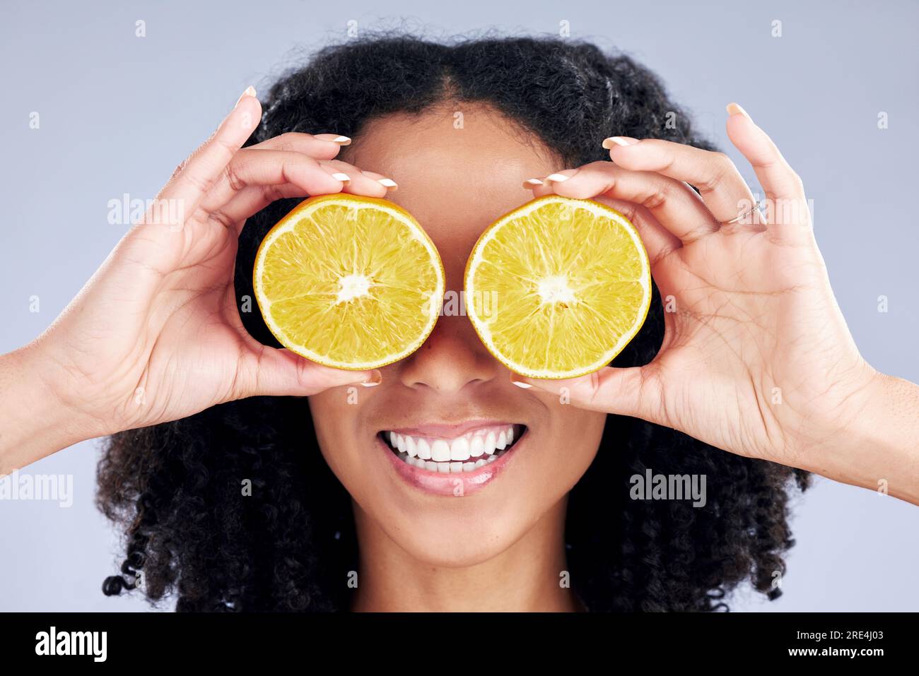 Woman, lemon eyes and skincare in studio for comic smile, health or ...