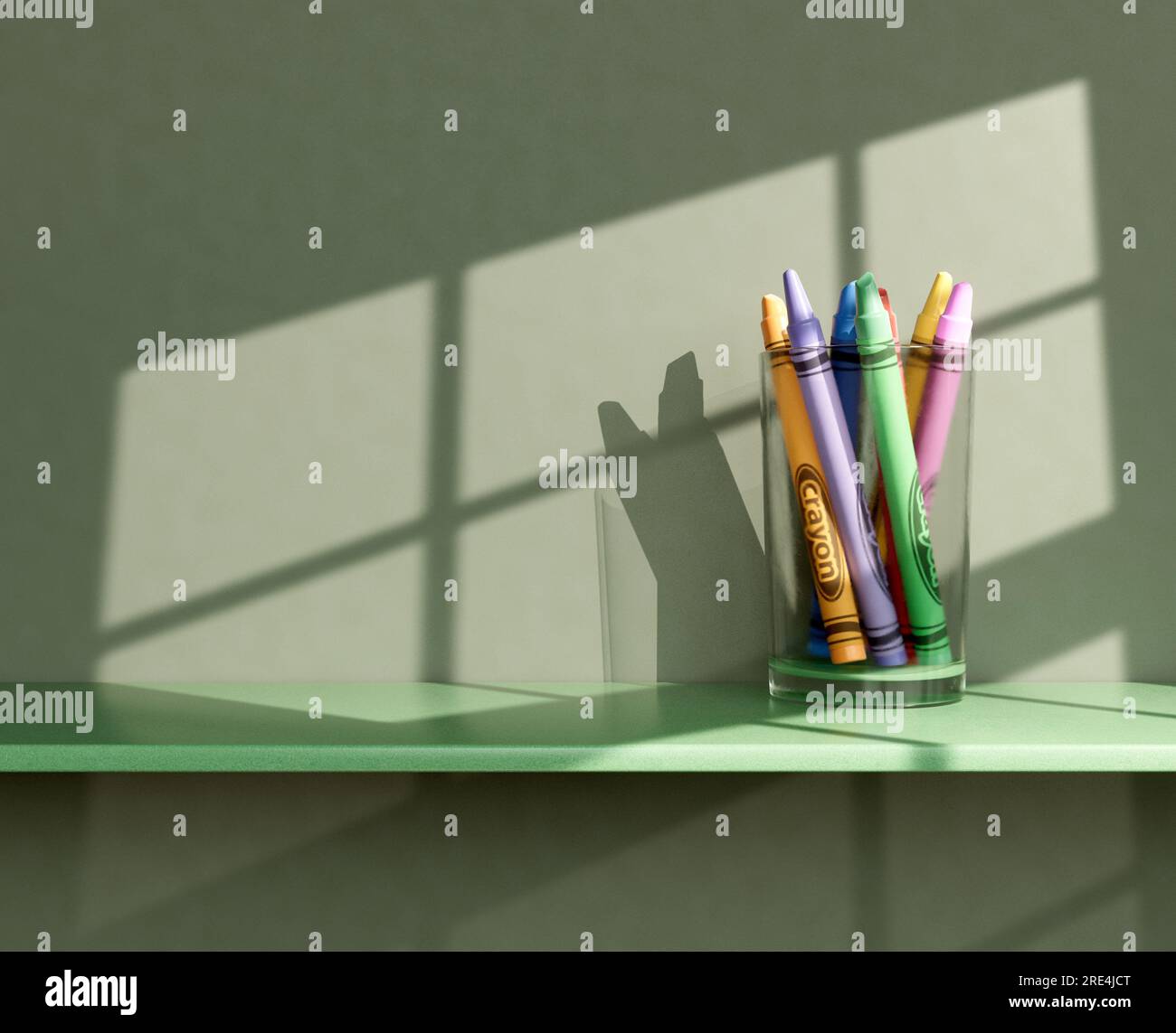 A concept showing a few colorful childrens wax crayons in a glass on a ...