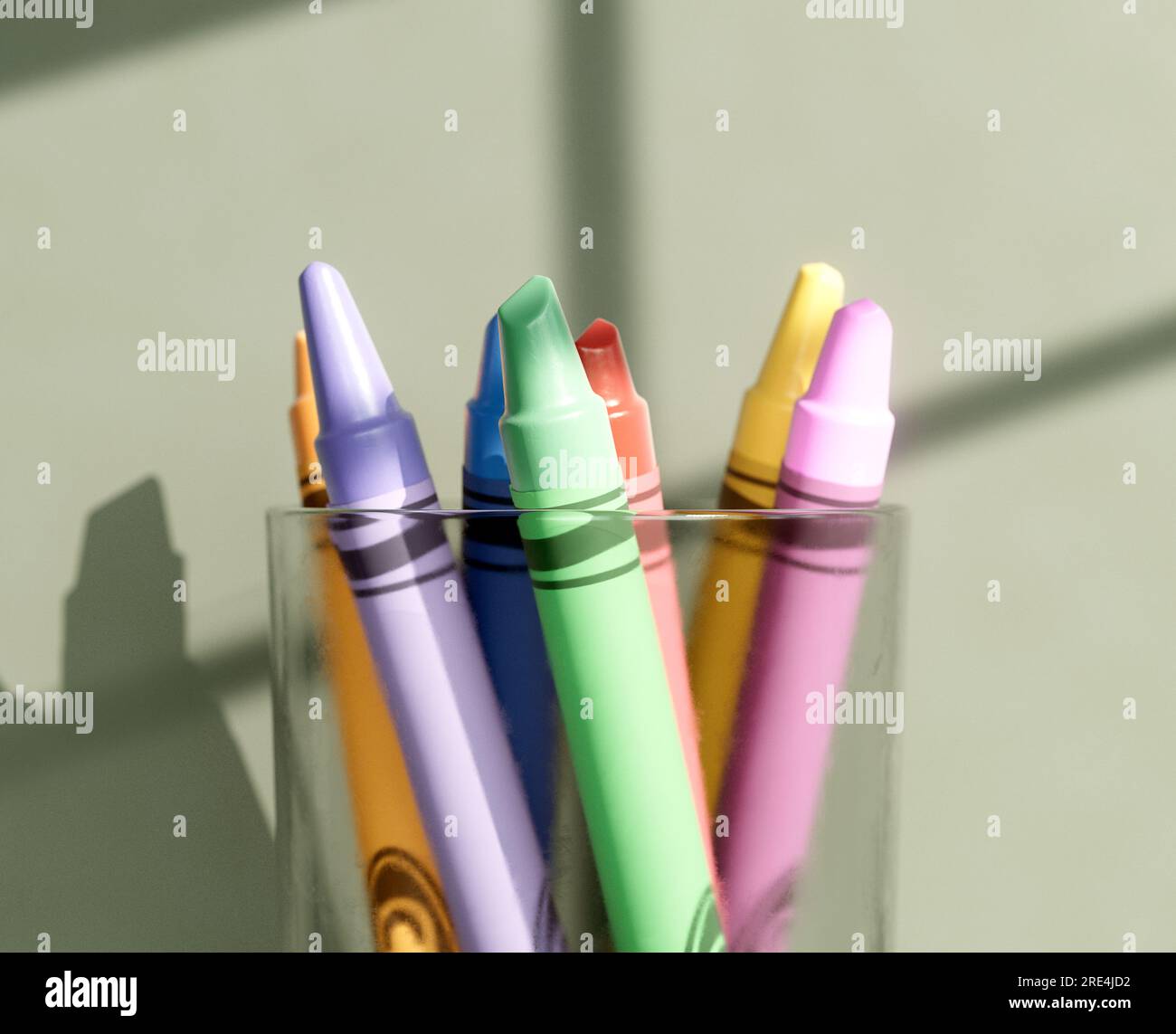 A concept showing a few colorful childrens wax crayons in a glass on a ...