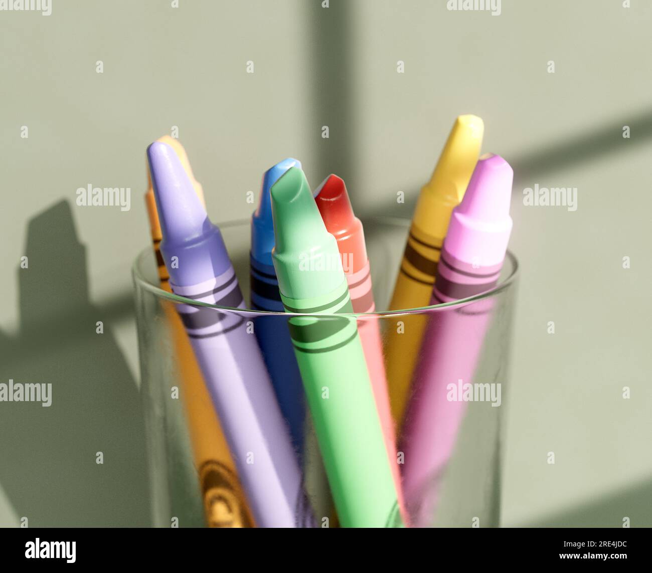 A concept showing a few colorful childrens wax crayons in a glass on a ...