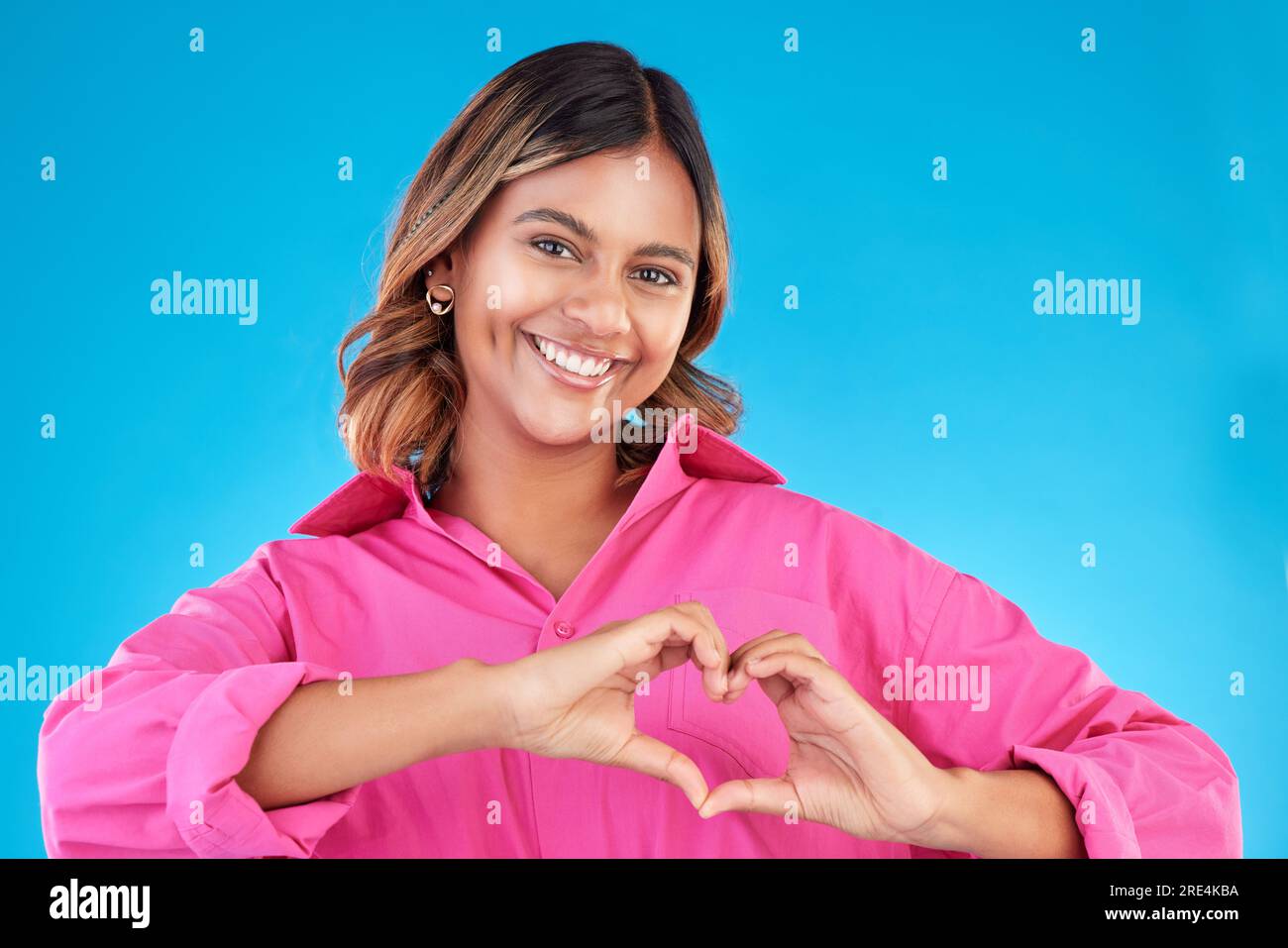 Woman, heart shape and smile portrait in studio for love, fashion or ...