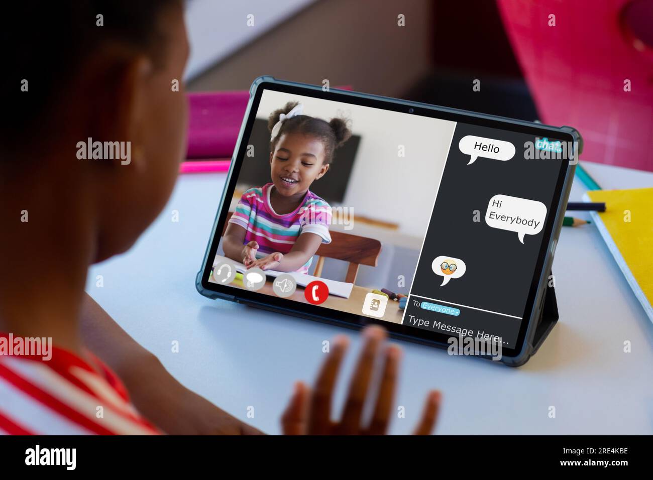 Rear view of a biracial boy waving while having a video call with african american girl on ...