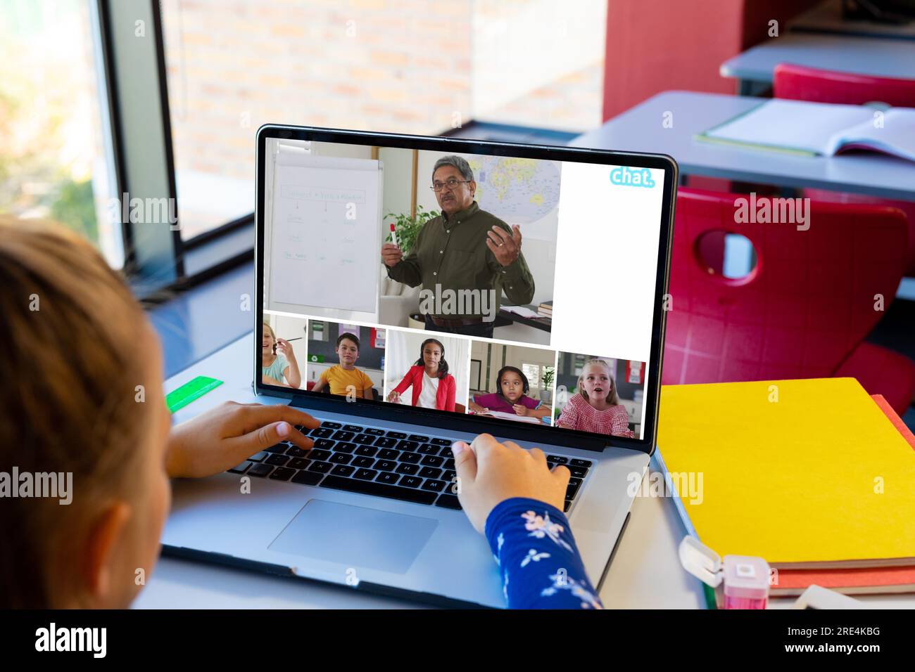 Caucasian girl having a video conference with male teacher and diverse ...