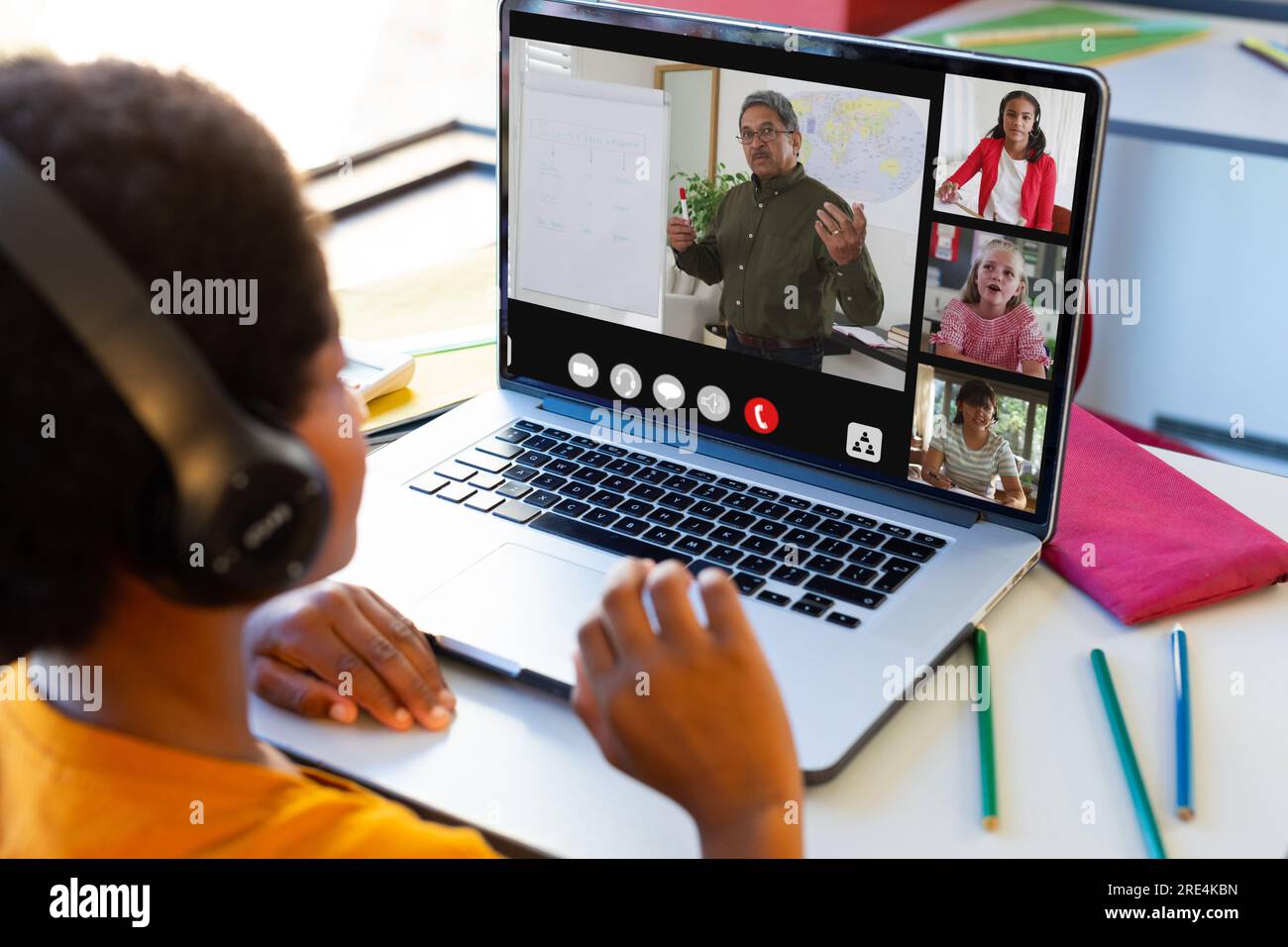 Biracial boy having a video conference with male teacher and diverse students on laptop Stock ...