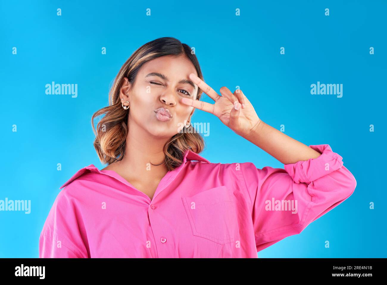 Wink, kiss and peace sign with portrait of woman in studio for support ...