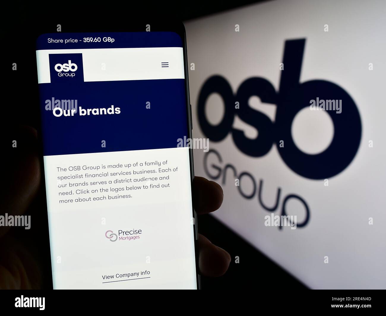 Person holding cellphone with web page of British financial company OSB ...
