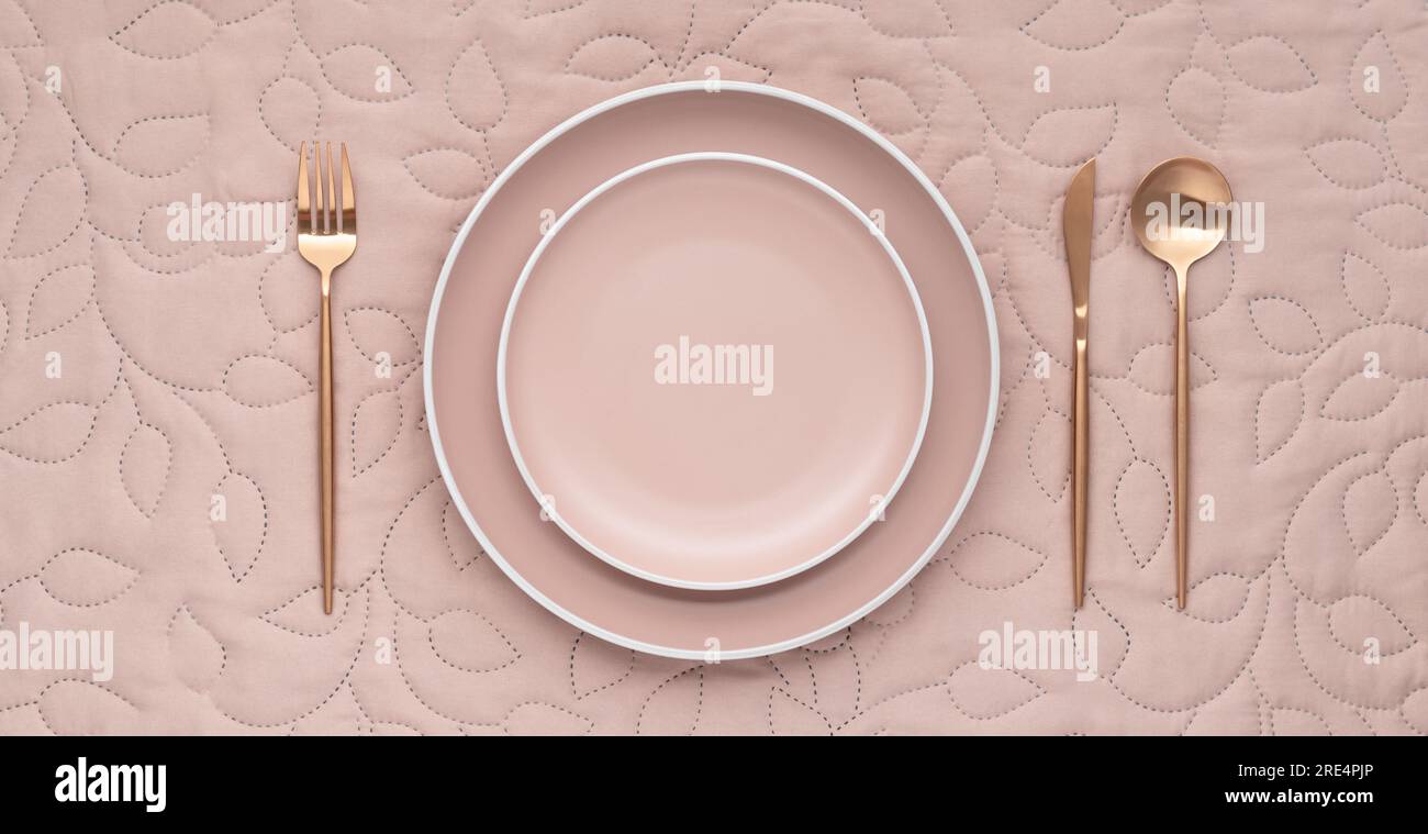 Festive table setting on beige tablecloth. Empty plate, gold cutlery ...