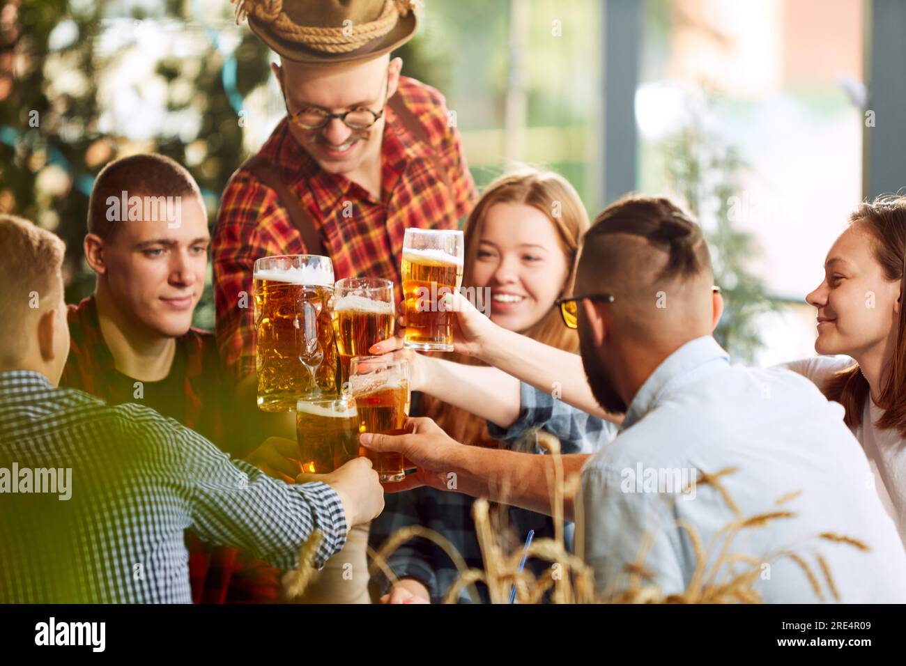 Young smiling people, cheerful friends meeting together in pub ...