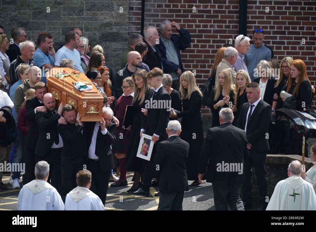 Family members follow behind a coffin at the funeral service of Eoin ...