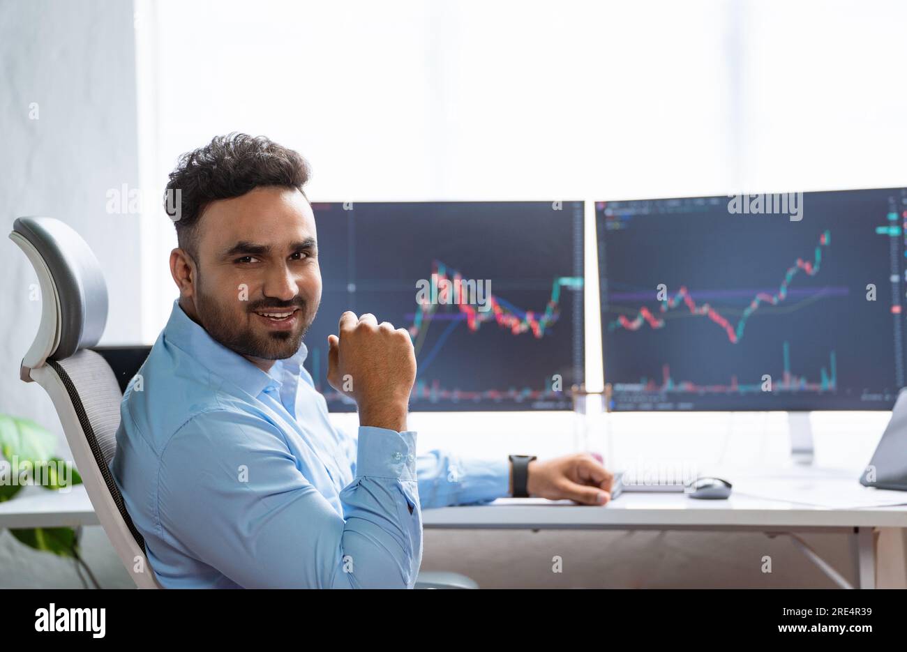 Happy smiling indian trader or stock broker by looking at camera at ...