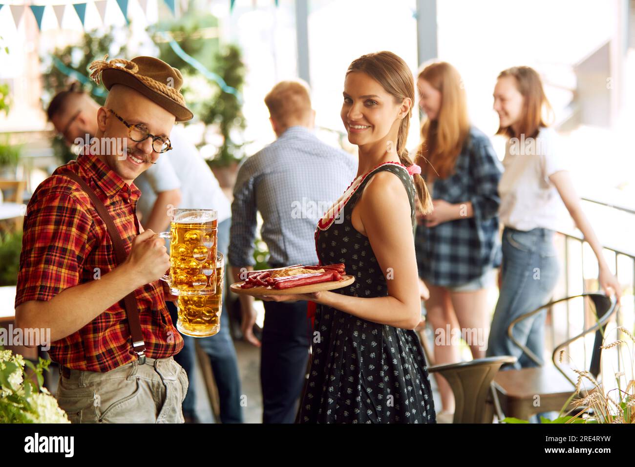Man and woman in traditional clothes standing with lager beer and ...