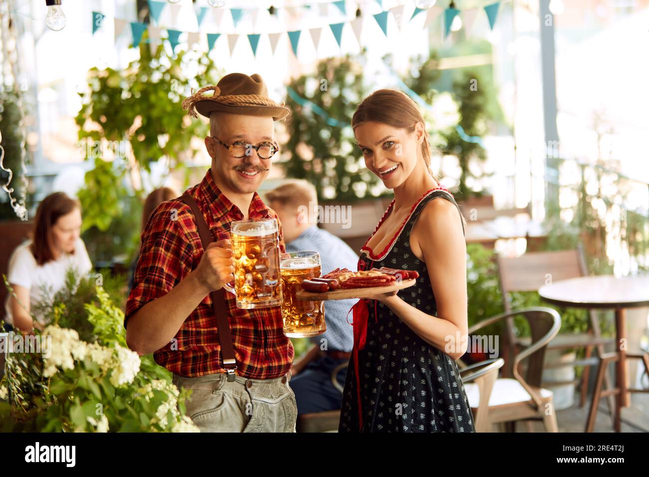 Man and woman in traditional clothes standing with lager beer and ...