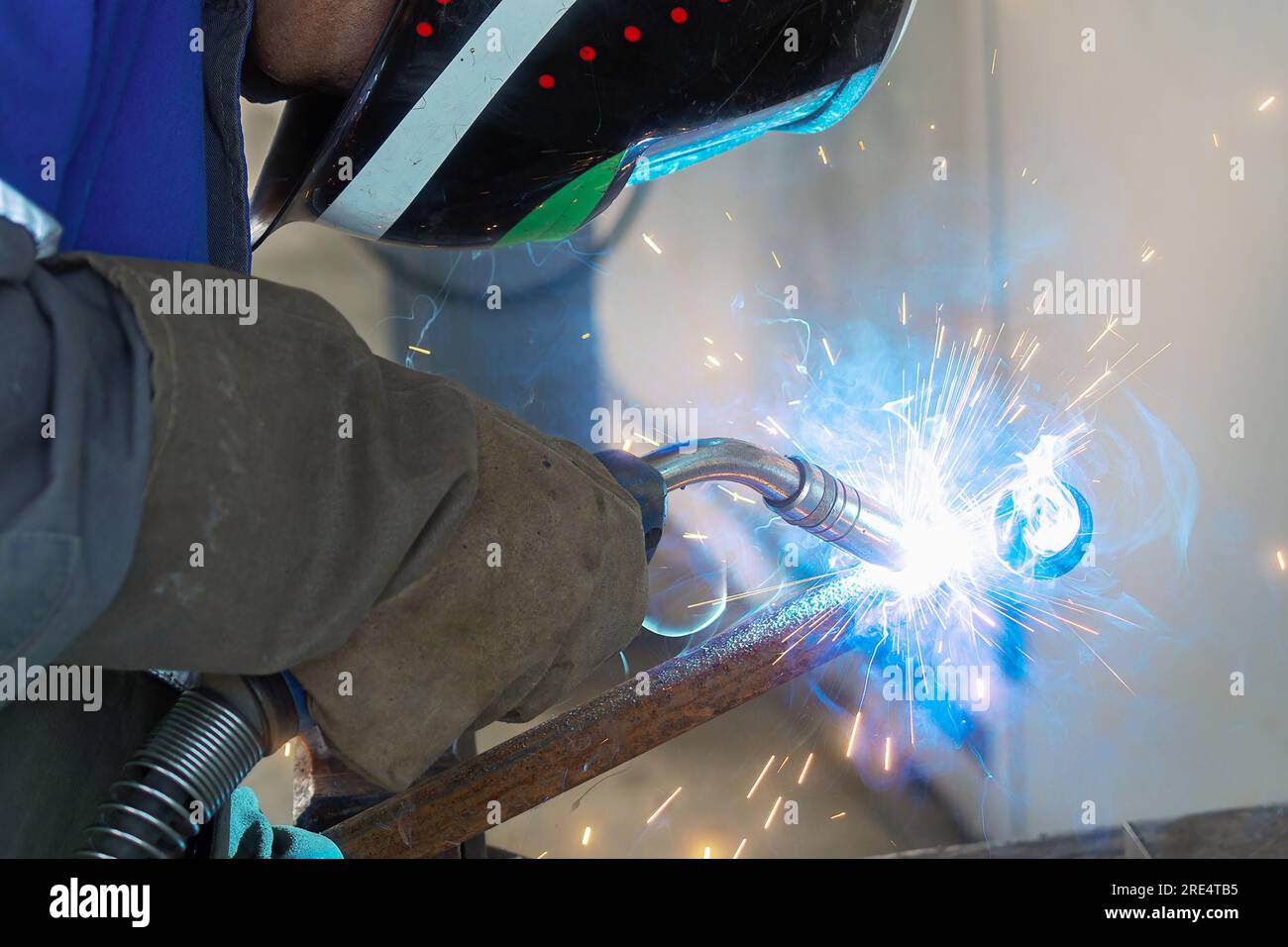 The welder works at the factory in the production workshop. a masked ...