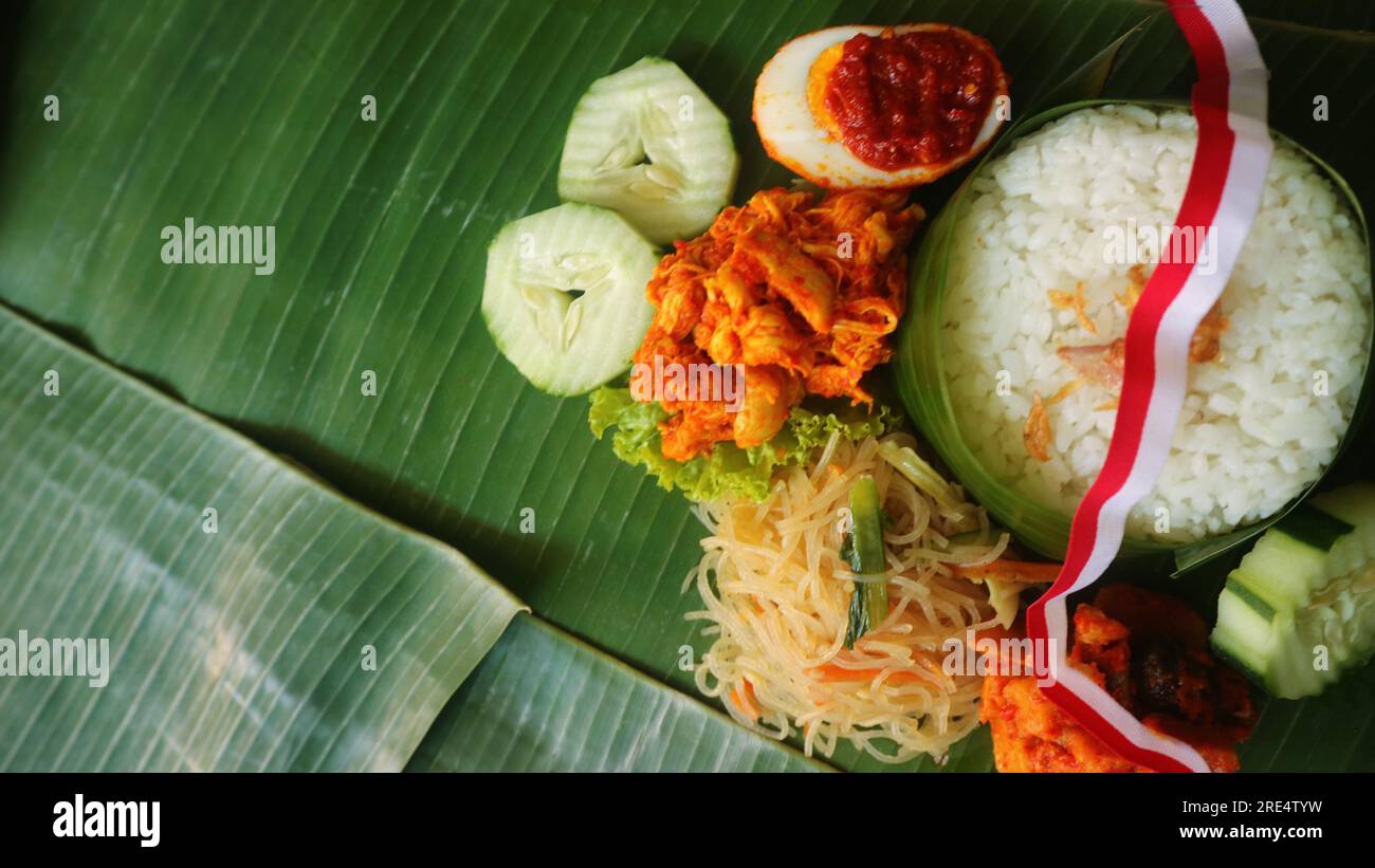 Savory rice, noodles, cucumber, seasoned potatoes on a banana leaf ...