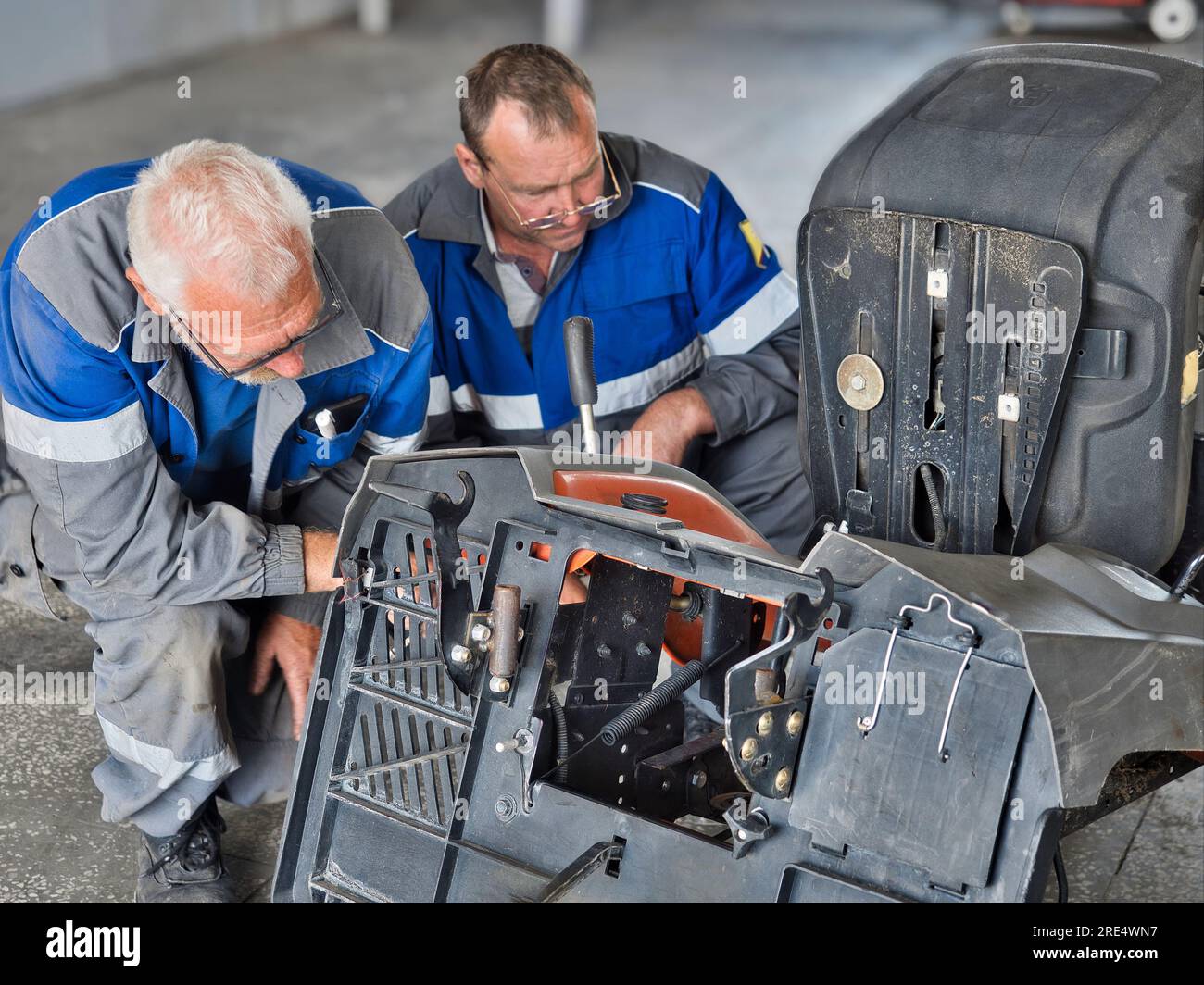 Two mechanics are repairing appliances in garage. Professional car ...