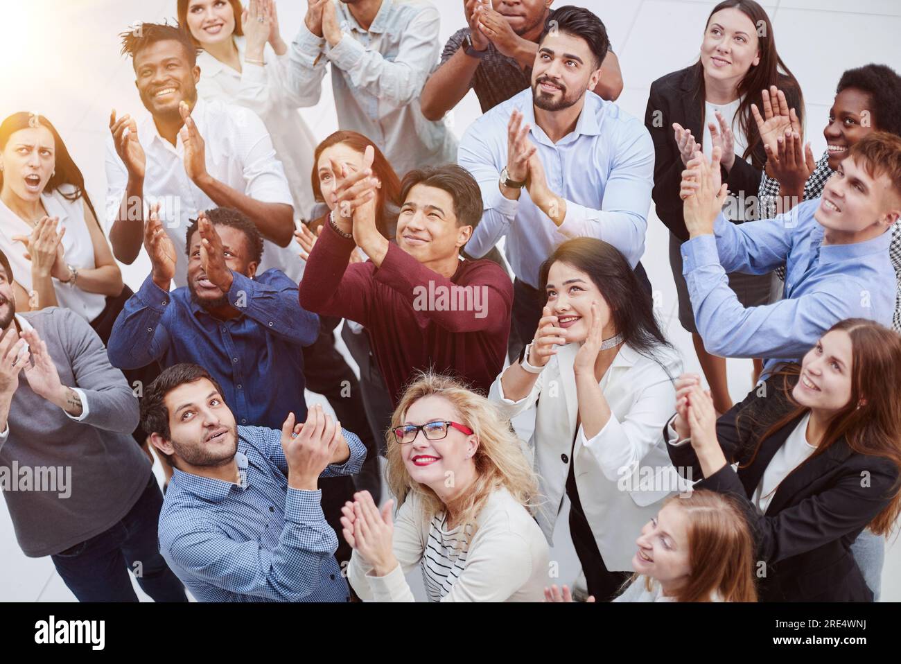 Shot of a group of young people pointing towards something above them ...