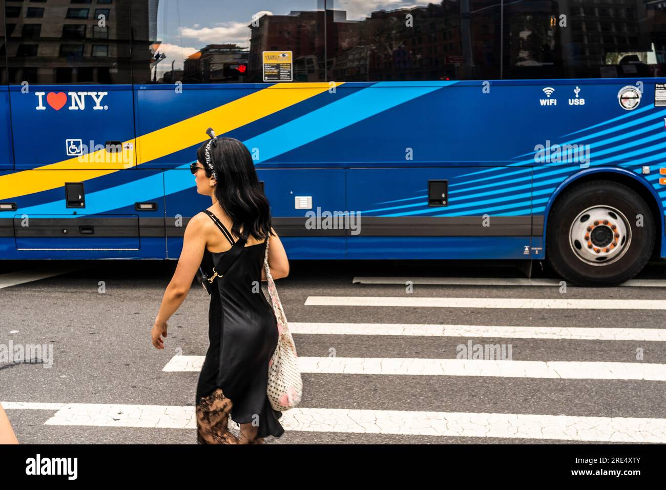 Woman waits for bus before crossing in Lower Manhattan in New York on ...