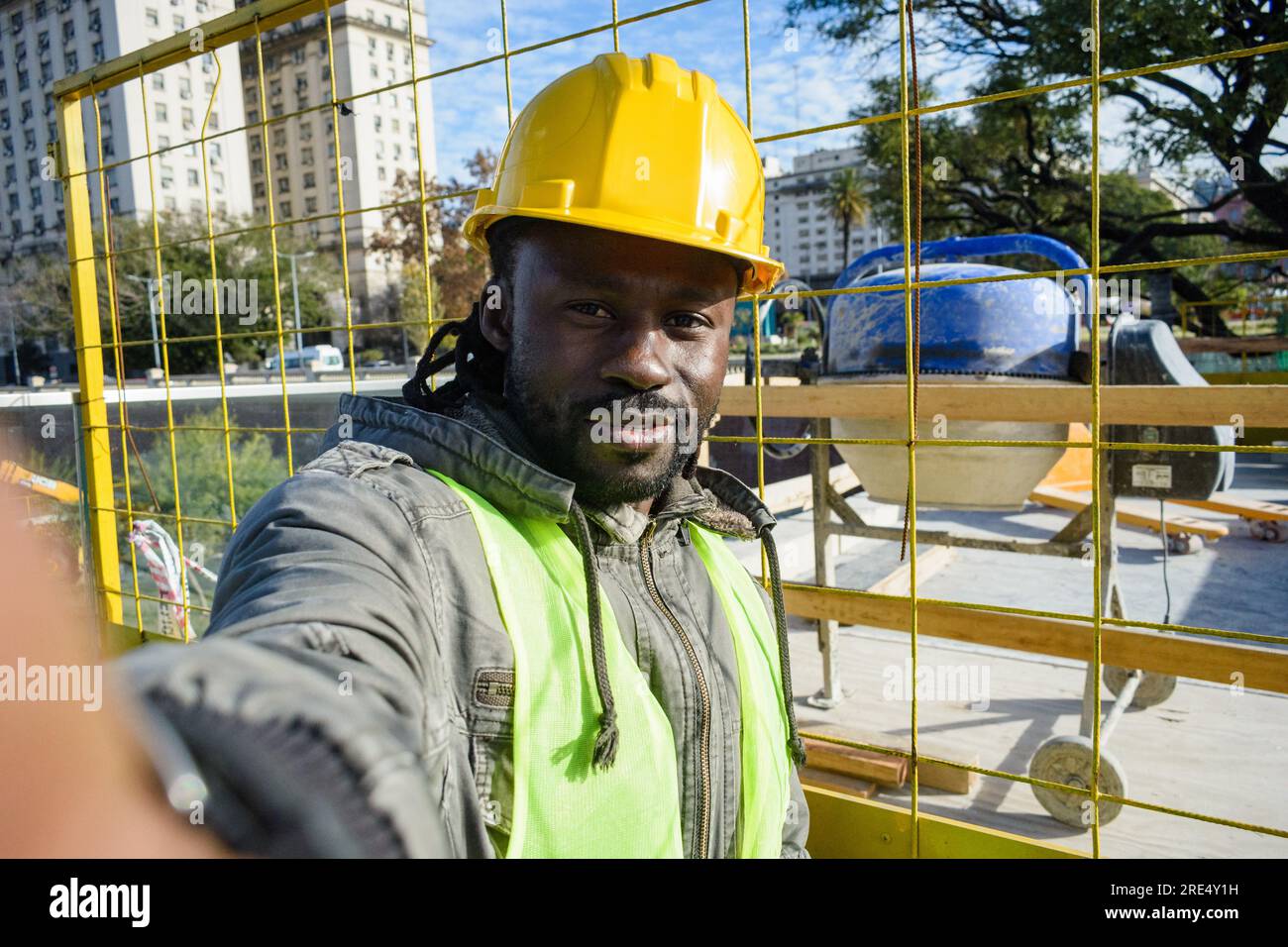 Selfie portrait of African man with beard and yellow safety helmet and ...