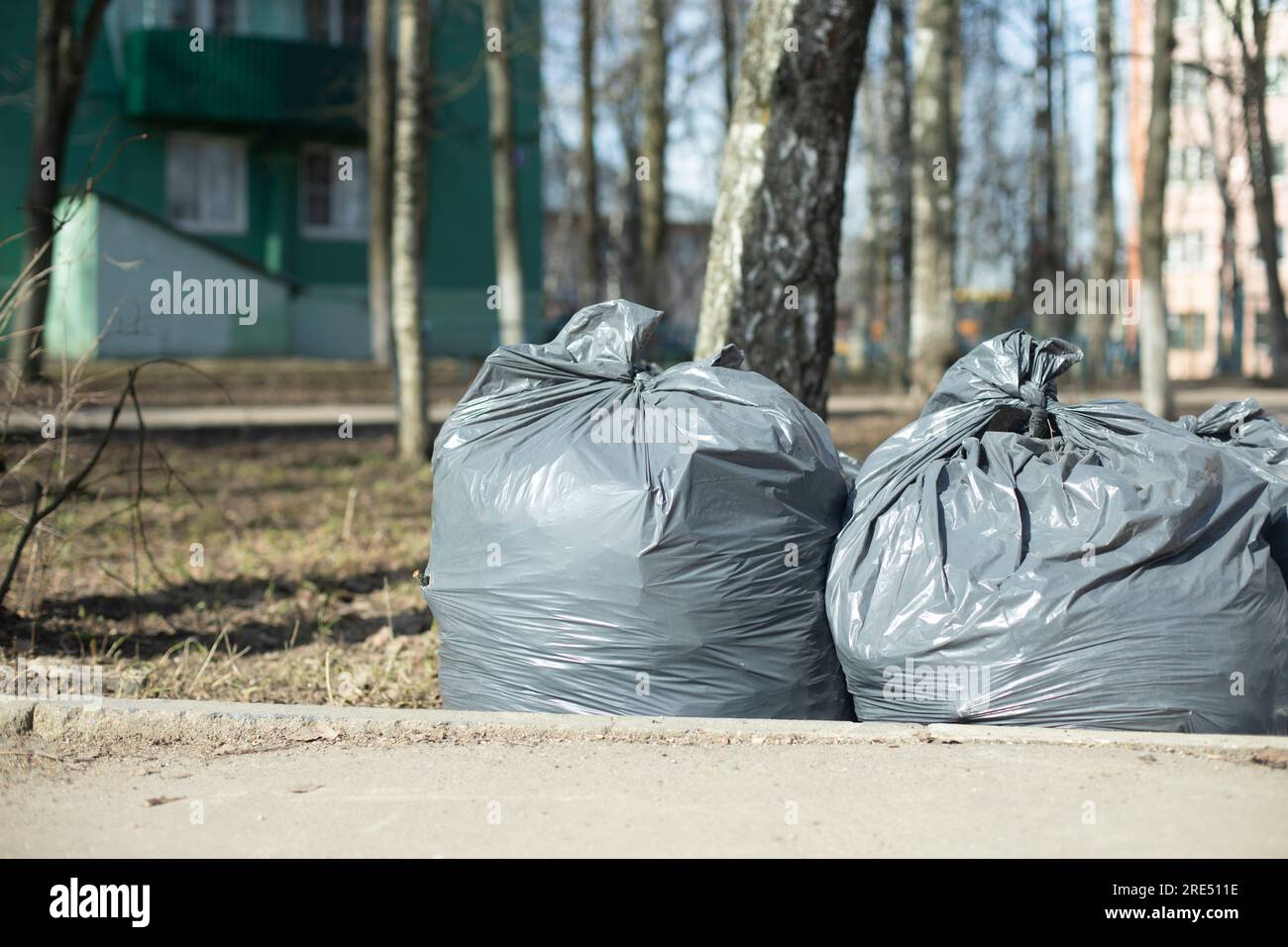 Garbage. Cleaning area. Black Garbage Bags. Restoring order in yard ...