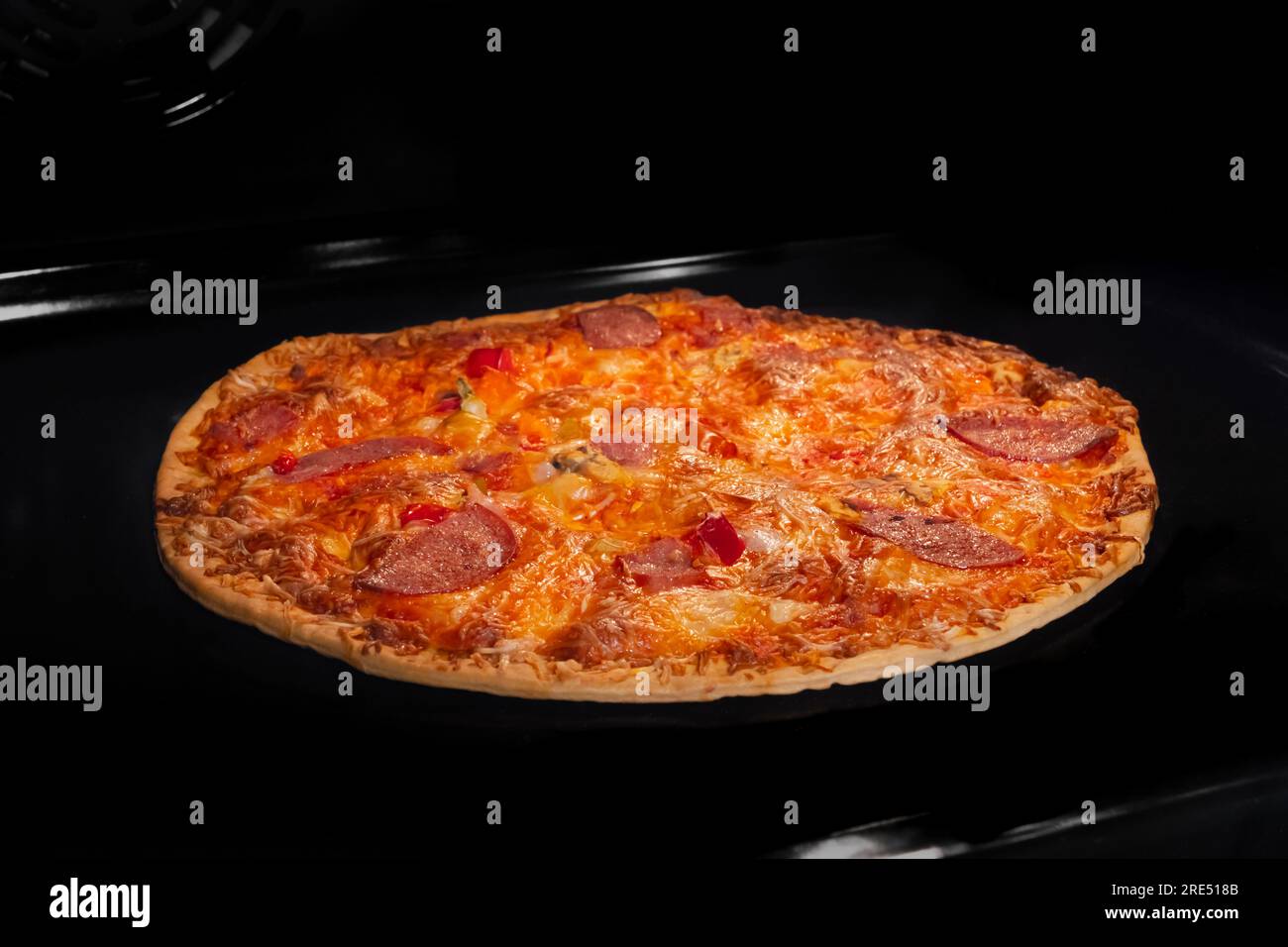 Burnt homemade pizza on tray in electric oven, black background Stock ...