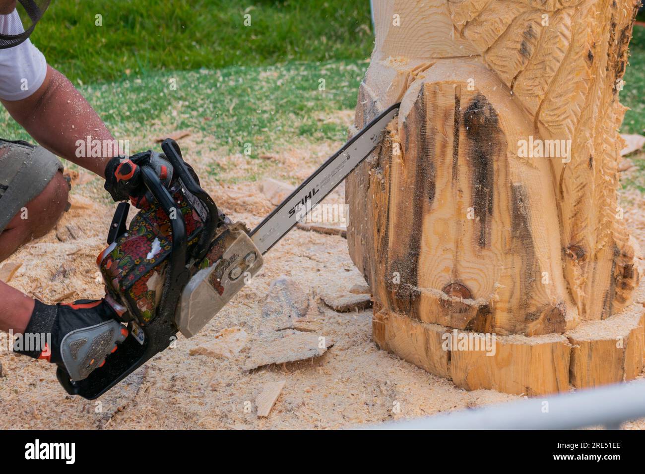 Close up: carpenter using chainsaw for carving wooden sculpture Stock ...