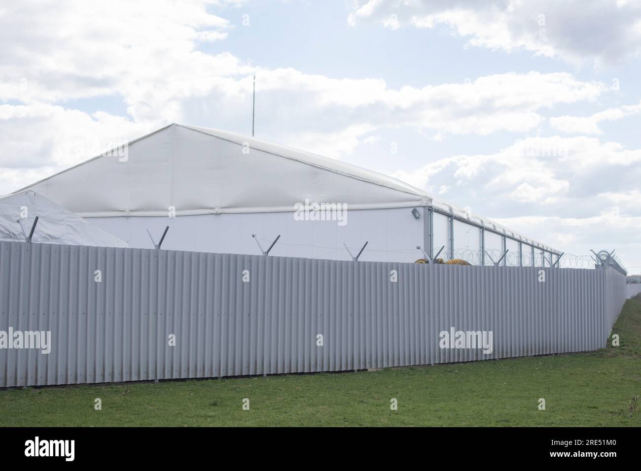 White industrial building. Steel fence along territory. Fence around ...