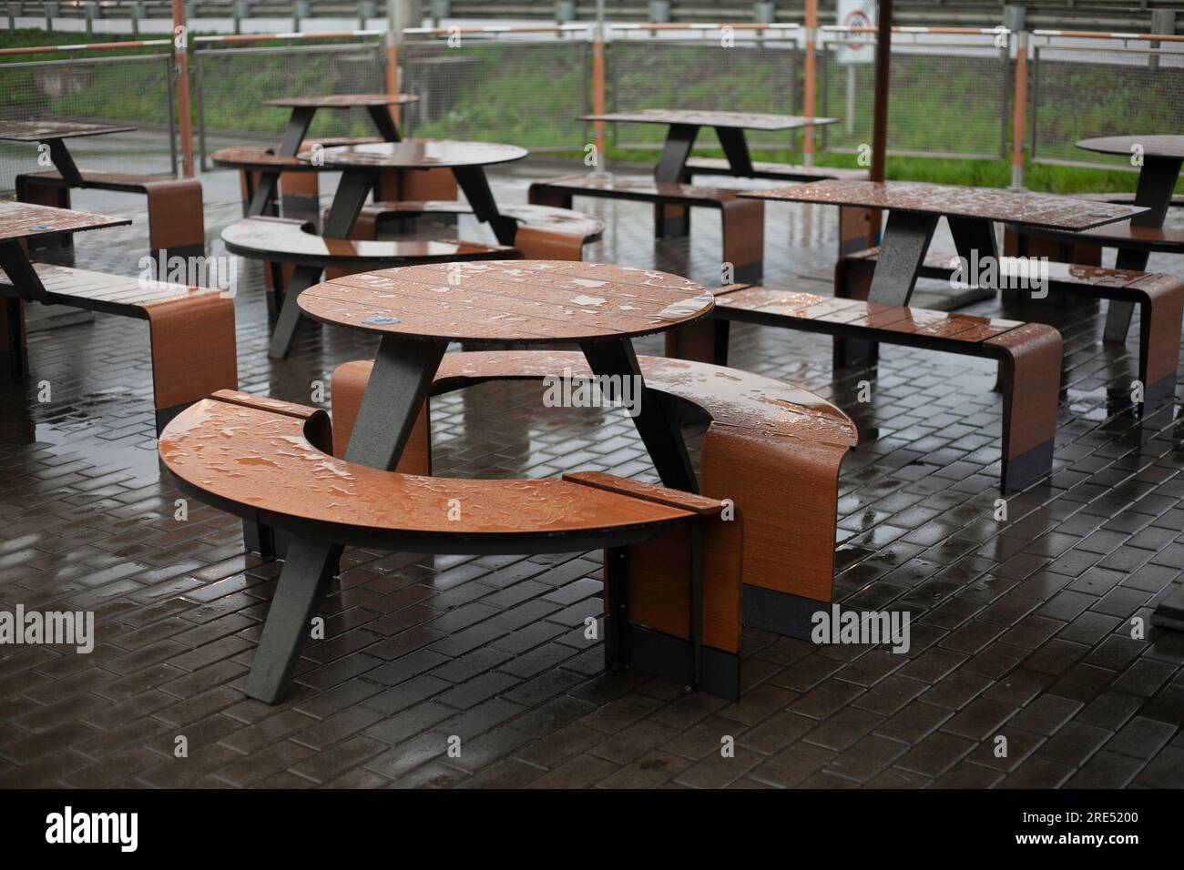 Tables of street restaurant. Rain in city. Empty spaces Stock Photo - Alamy