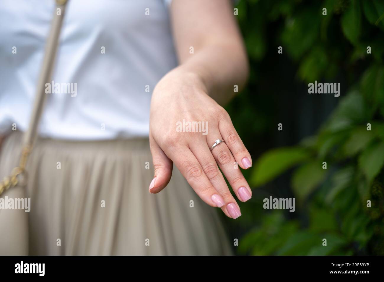 Woman with engagement or wedding ring on her hand. Showing her left ...