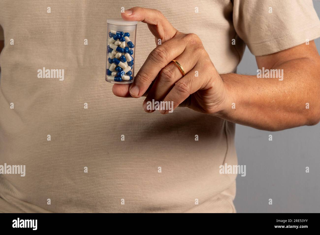Hand holding bottle of pills representing different diseases. At home ...