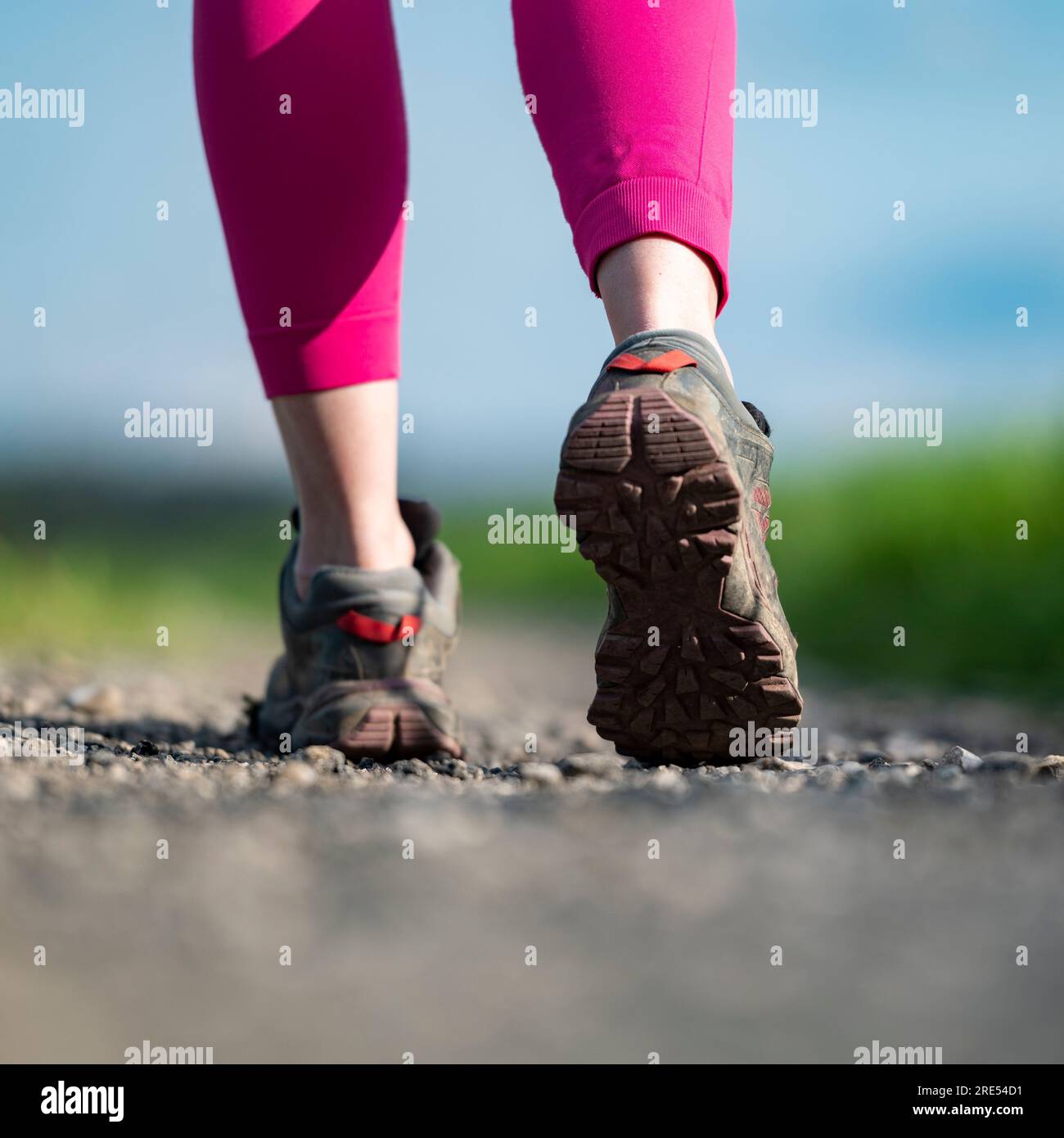Low angle closeup view of female legs stepping on gravel path in hiking ...
