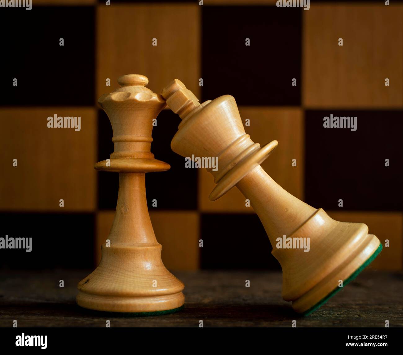 Wooden chess pieces Queen and King leaning against each other on a ...
