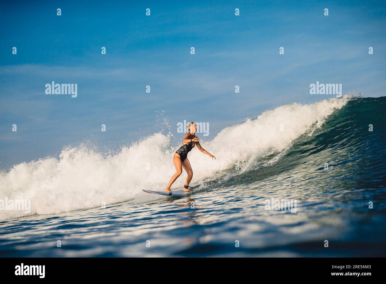 Surfer woman ride on ocean wave on surfboard. Woman during surfing with ...