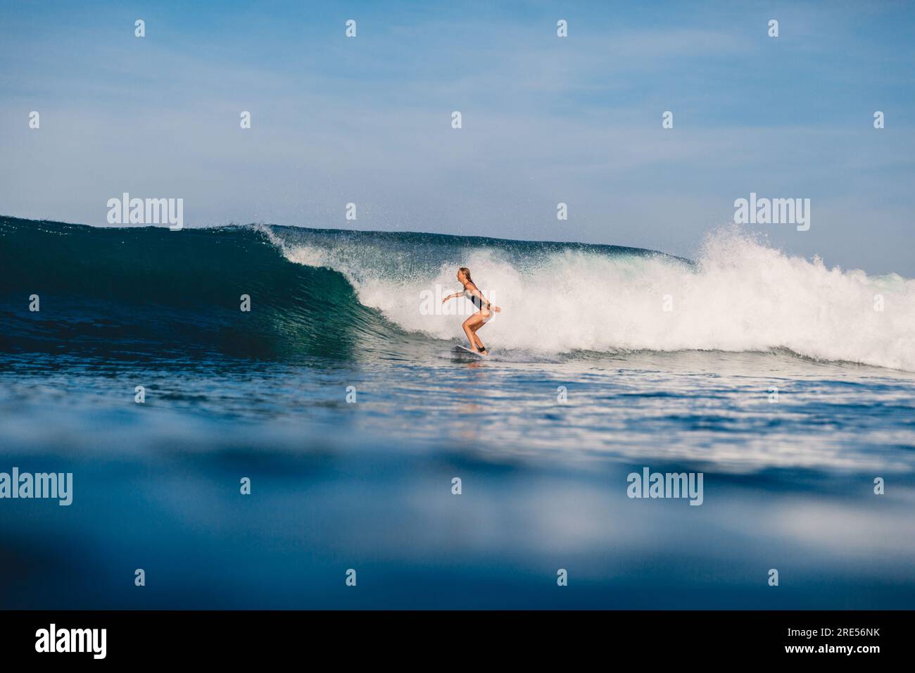 Surfer woman ride on ocean wave on surfboard. Woman during surfing with ...
