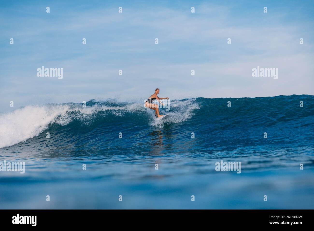 Surfer woman ride on ocean wave on surfboard. Woman during surfing with ...