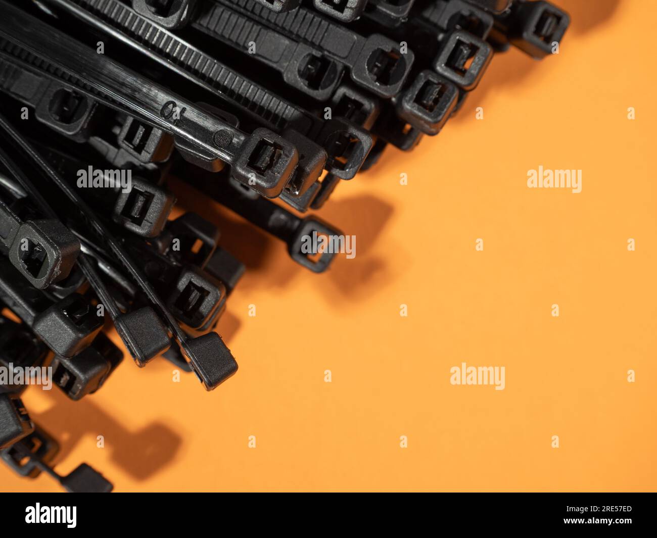 Plastic black ties on an orange background. Plastic ties for cables ...