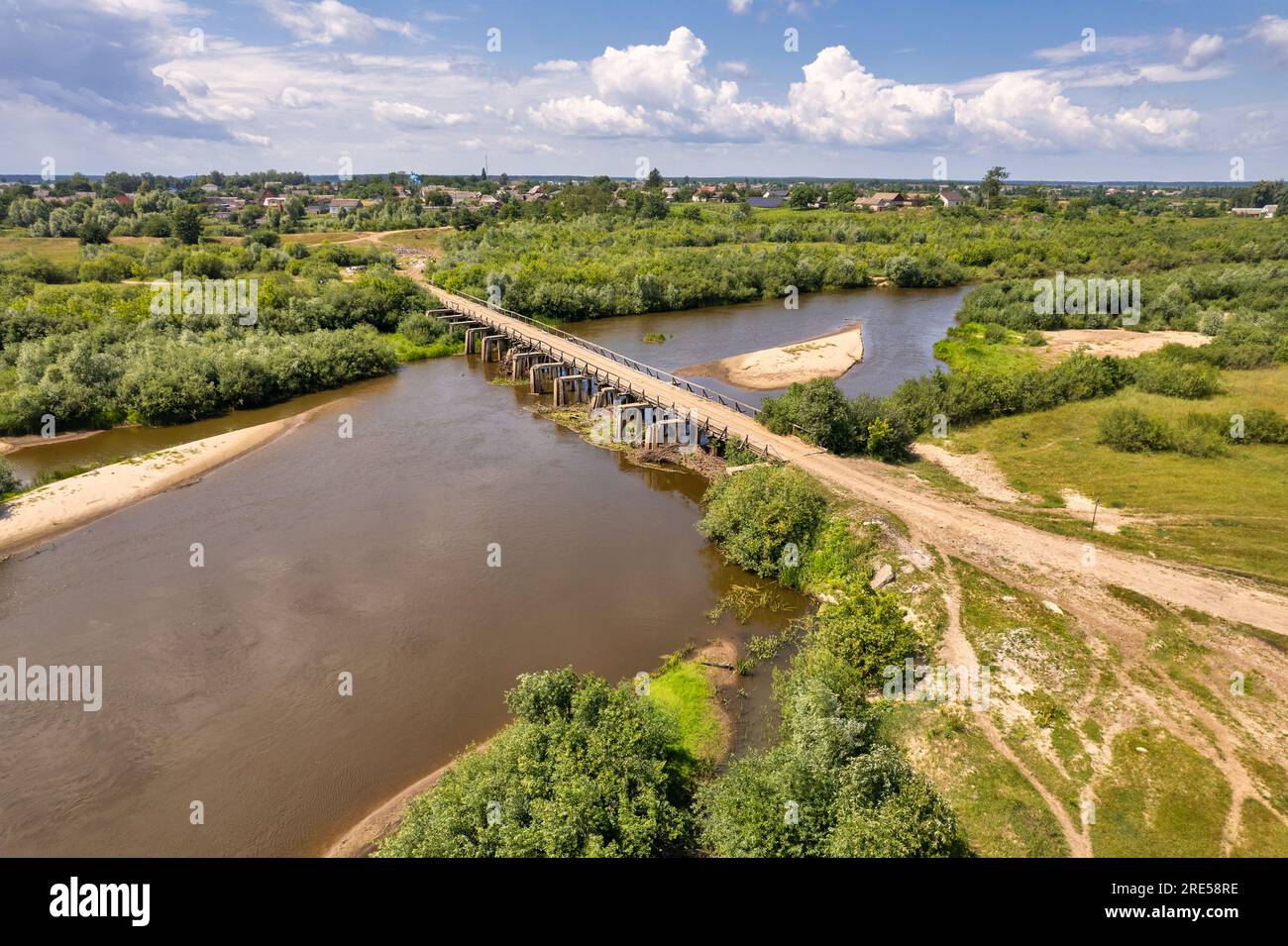 Aerial drone top view over Sluch river, old bridge and Liukhcha village ...