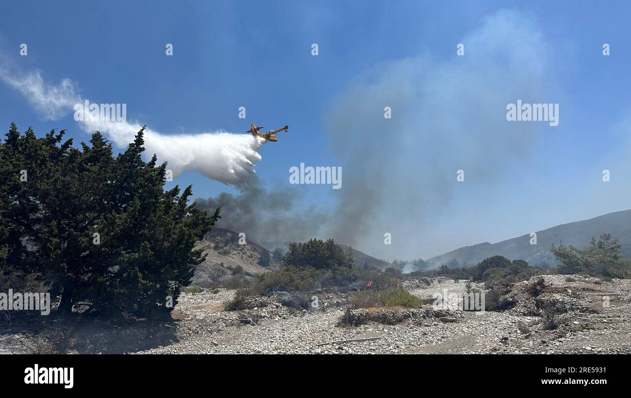 An aerial firefighting aircraft extinguishes a fire spreading in the ...