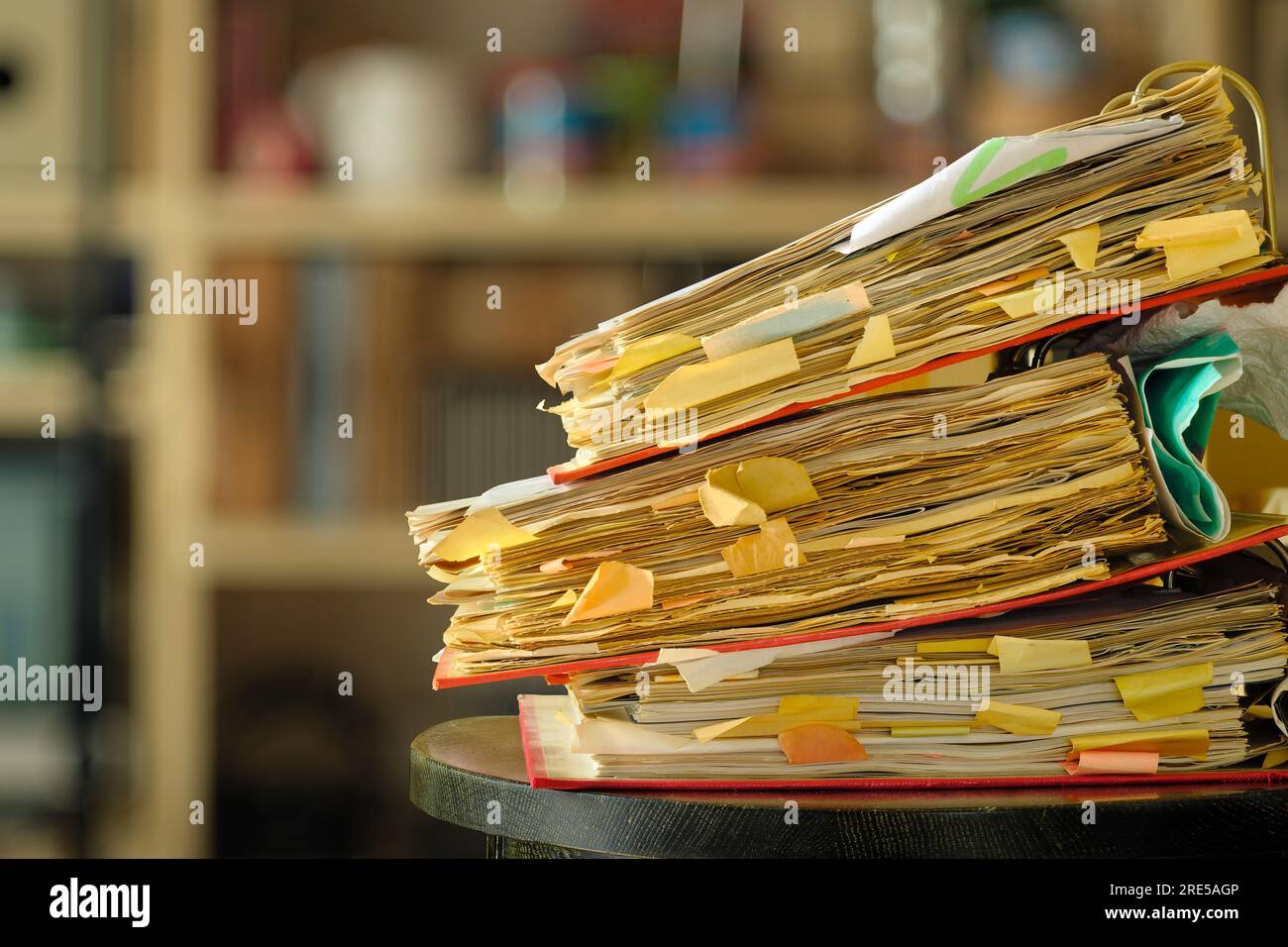 stack of dusty messy file folders with narrow depth of field, blurred ...