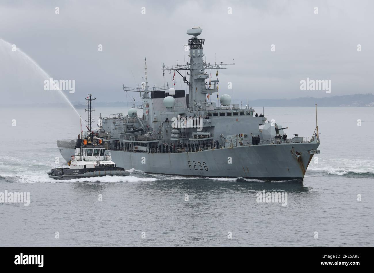 A tug provides a water cannon farewell for the Royal Navy frigate HMS MONTROSE (F236). The ship ...