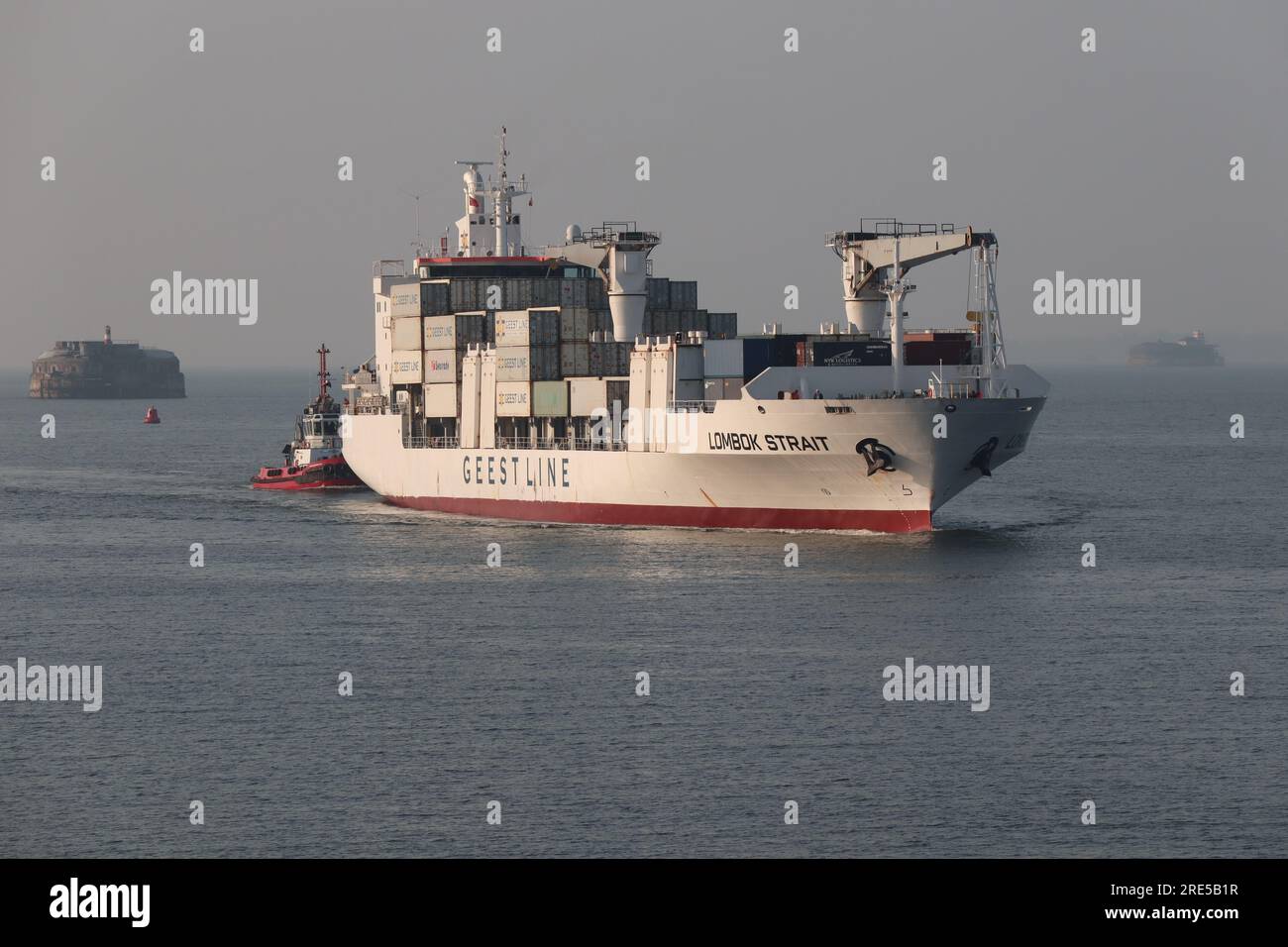 A tugboat at the stern of the refrigerated cargo ship MV LOMBOK STRAIT ...