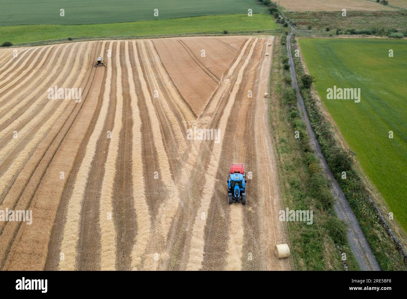 Aerial drone view of a Baler and Combine Harvester harvesting a crop ...