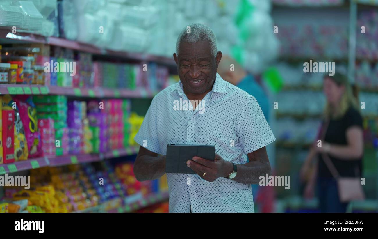 One Black Senior Manager Checking Grocery Store Inventory with Tablet ...